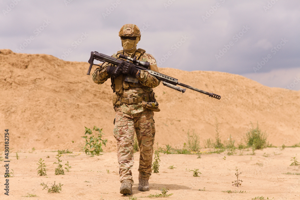 Armed special forces soldier with rifle in the desert during the ...