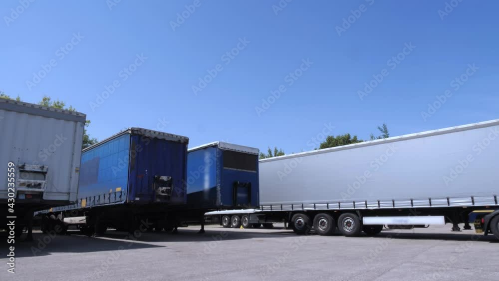 White lorry with cargo trailer drives back into parking place and parks ...