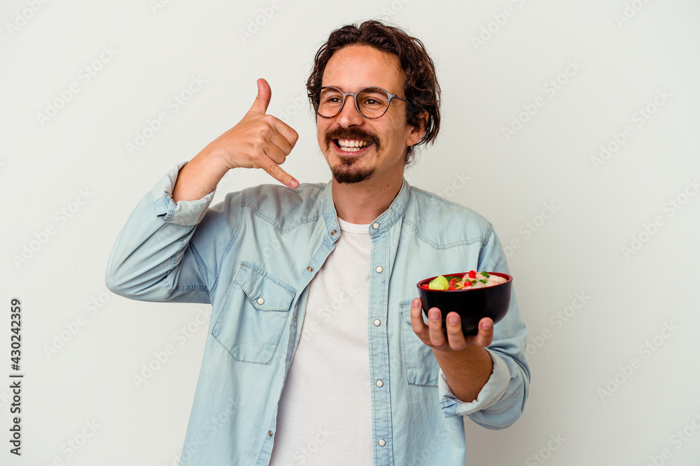 Young caucasian man eating a ramen isolated on white background showing ...