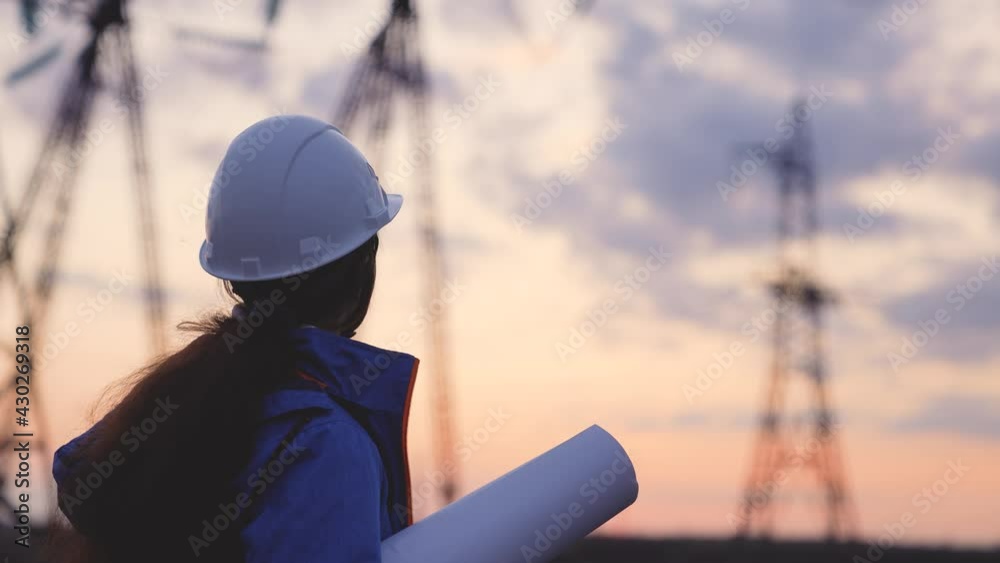 electrical engineer worker in helmet silhouette working at sunset near ...