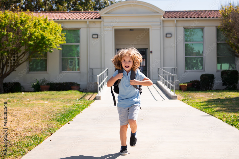 Happy smiling kid is running to school. Child boy with bag go to ...