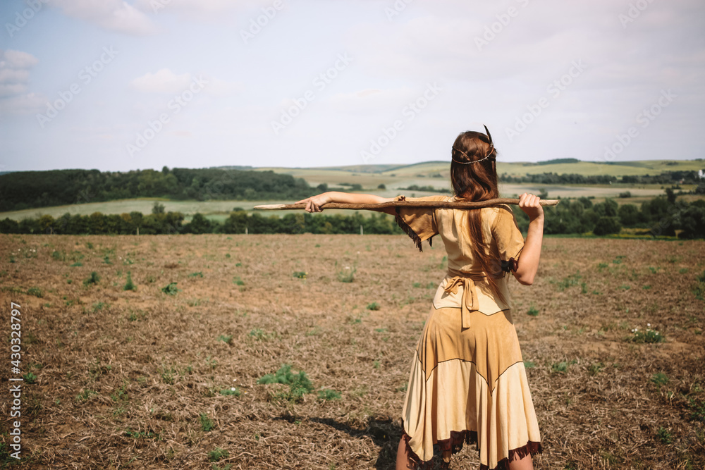 Beautiful strong woman with a braid and feather in a native american ...