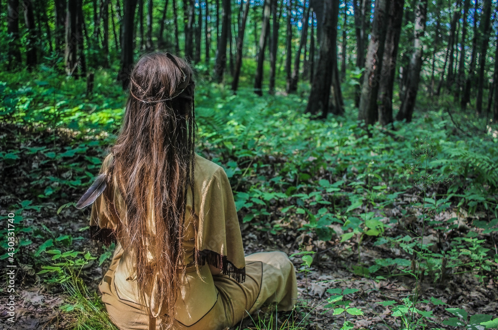 Beautiful woman in traditional tribal dress meditating in the woods ...