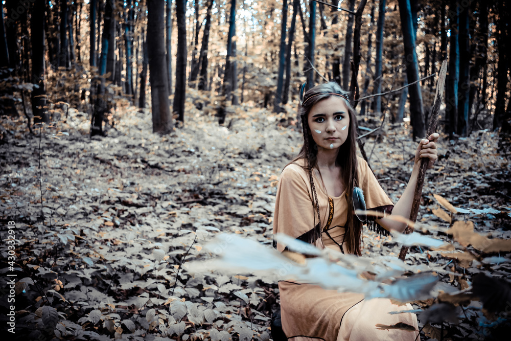 Beautiful woman in traditional tribal dress meditating in the woods ...