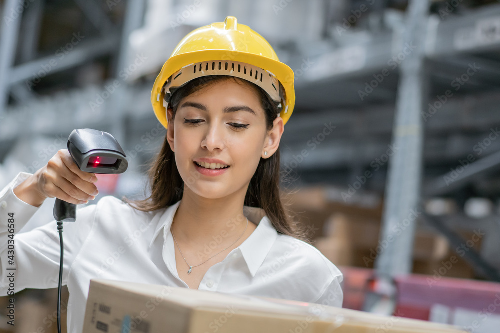 Portrait of warehouse female worker scanning barcode on parcel box in ...