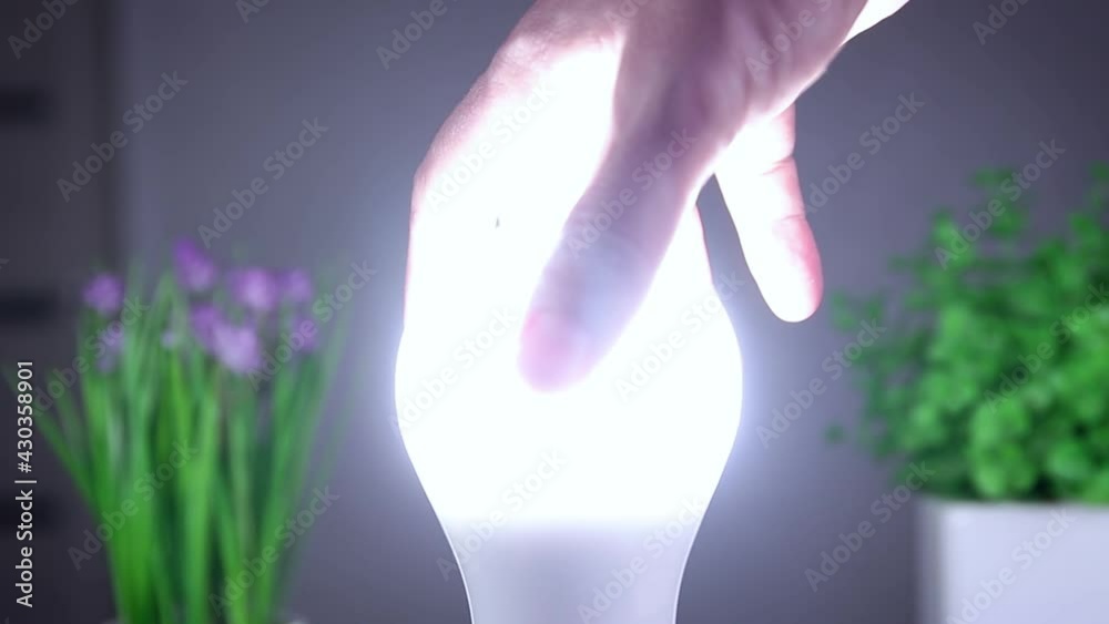 Man Rotates with His Hand a Led Bulb in Its Electrical Socket. Energy ...