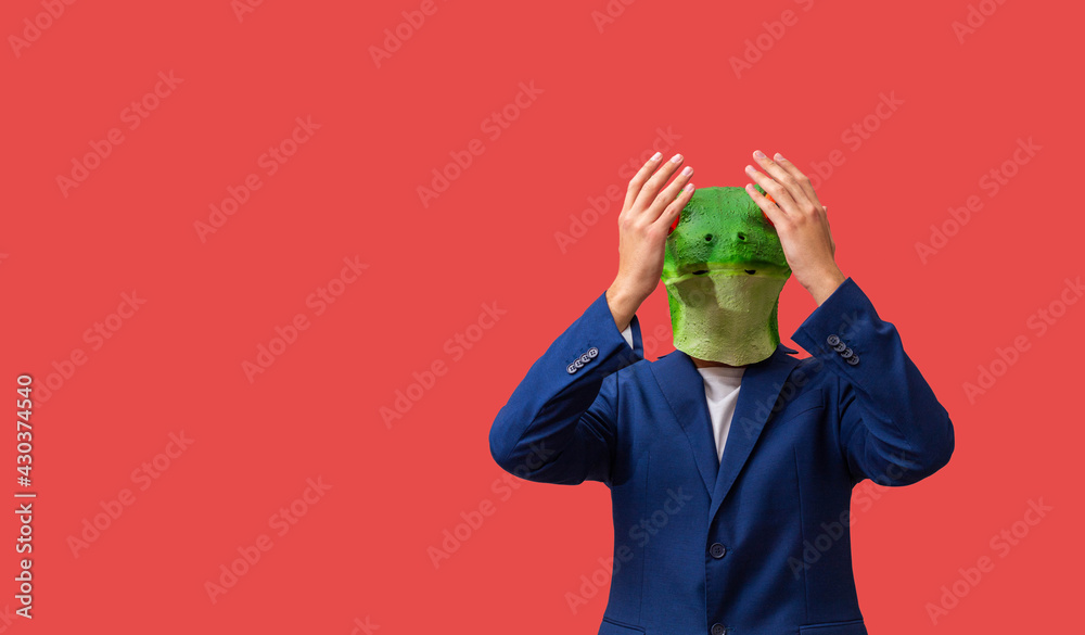 man with frog mask with bulging eyes showing shyness and hiding with ...