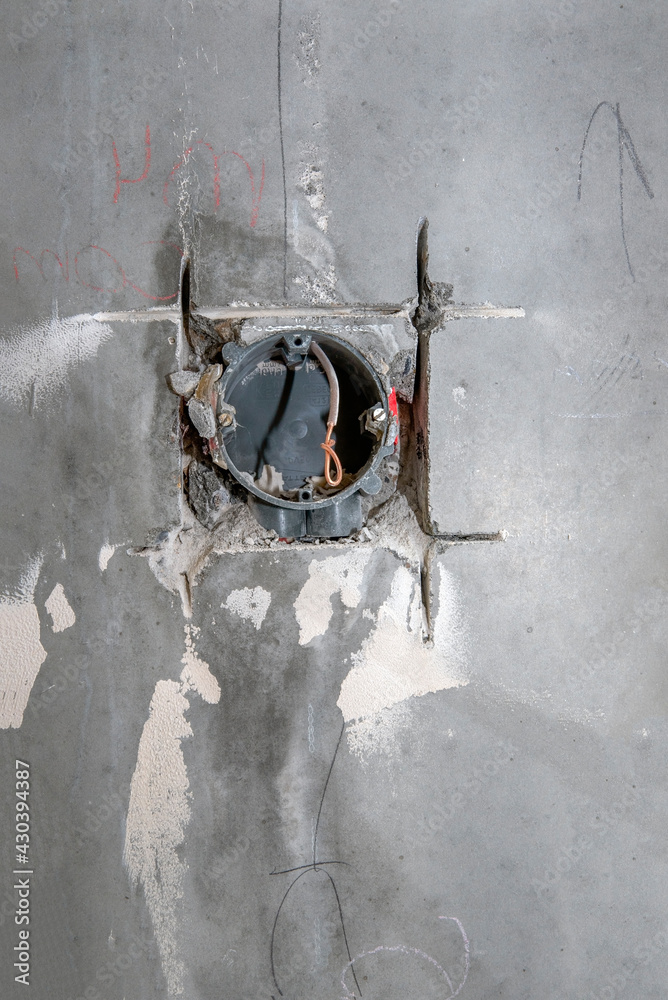 Foto de Electrical wire and opened junction box on the concrete wall ...