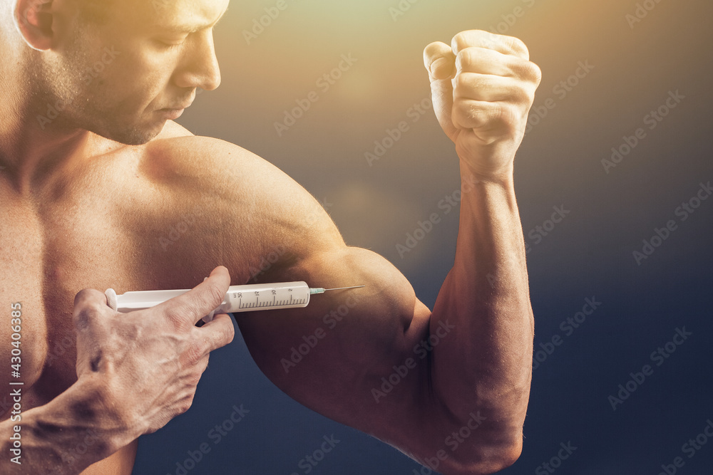 Bodybuilder makes injection of vitamins. Photo of sporty man with ...