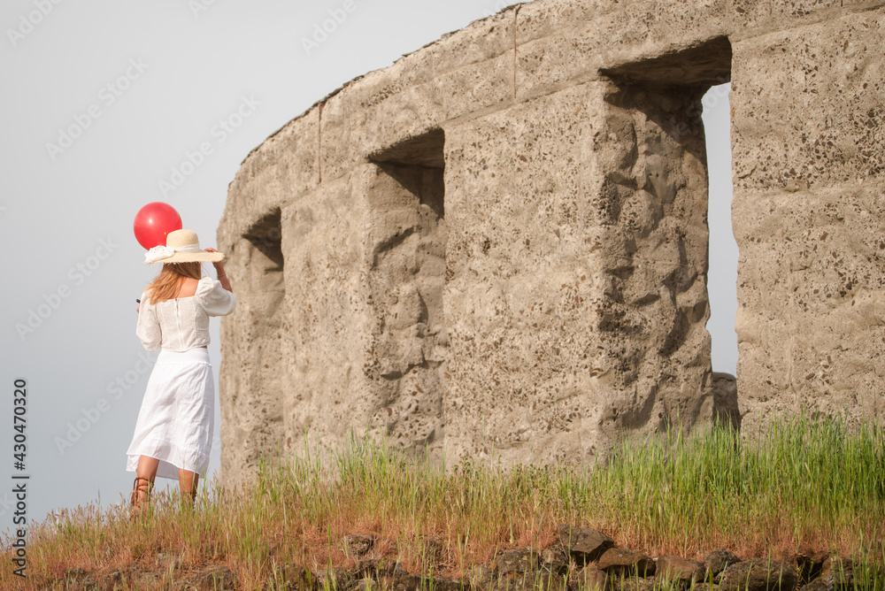 Fotka „woman in white dress with straw hat facing away standing alone ...