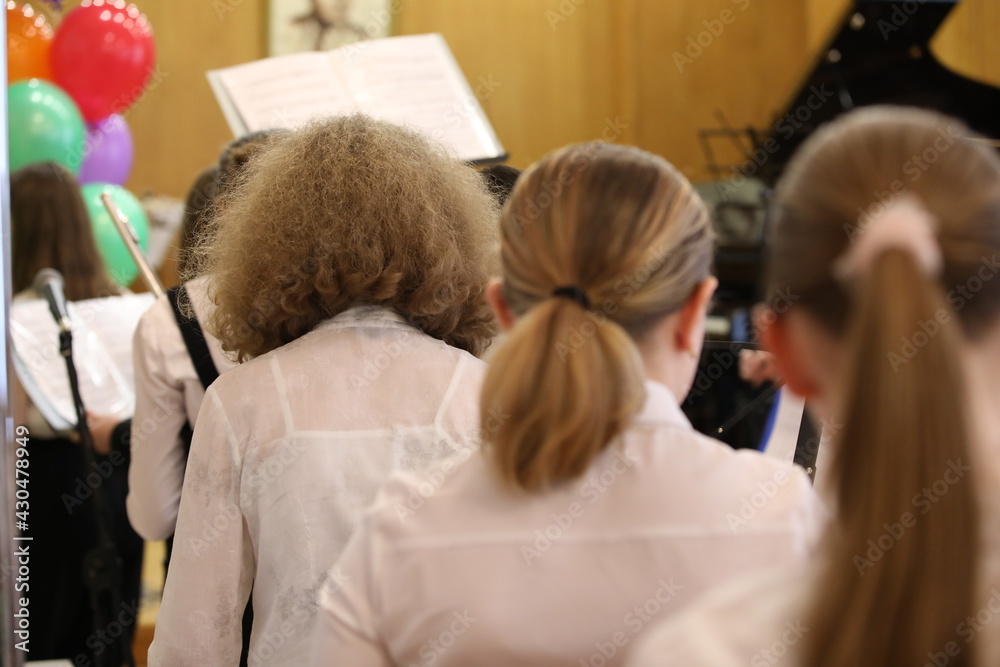 Students girls in white shirts sit behind each other in the classroom ...