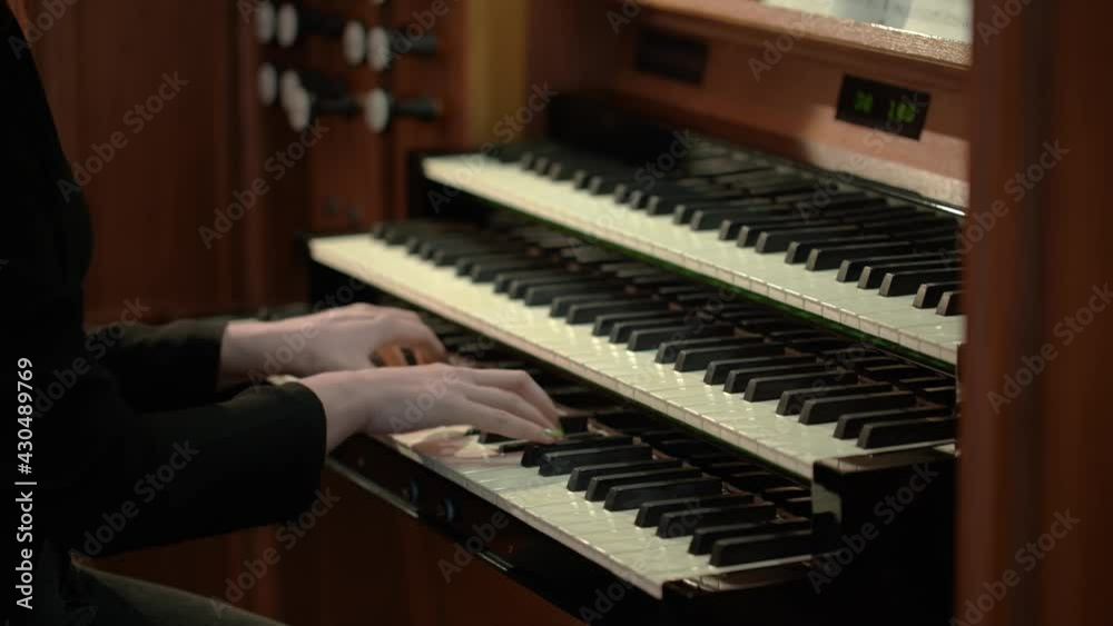 Women's hands play organ music in a church at a wedding. The musician's ...