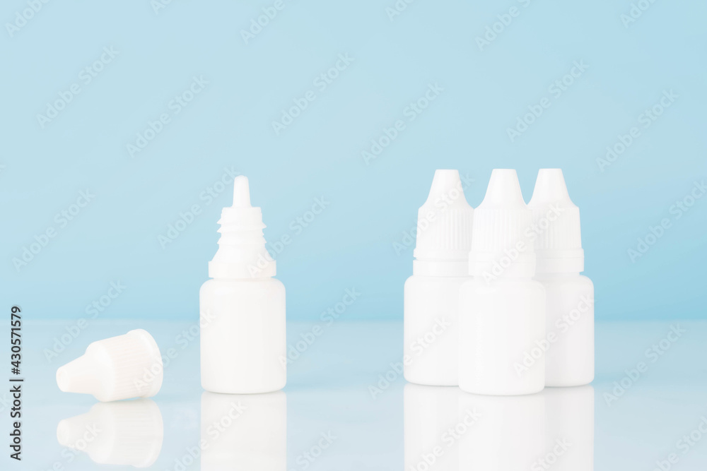 Eye drop or ear drop bottles on light blue background. Blank white ...