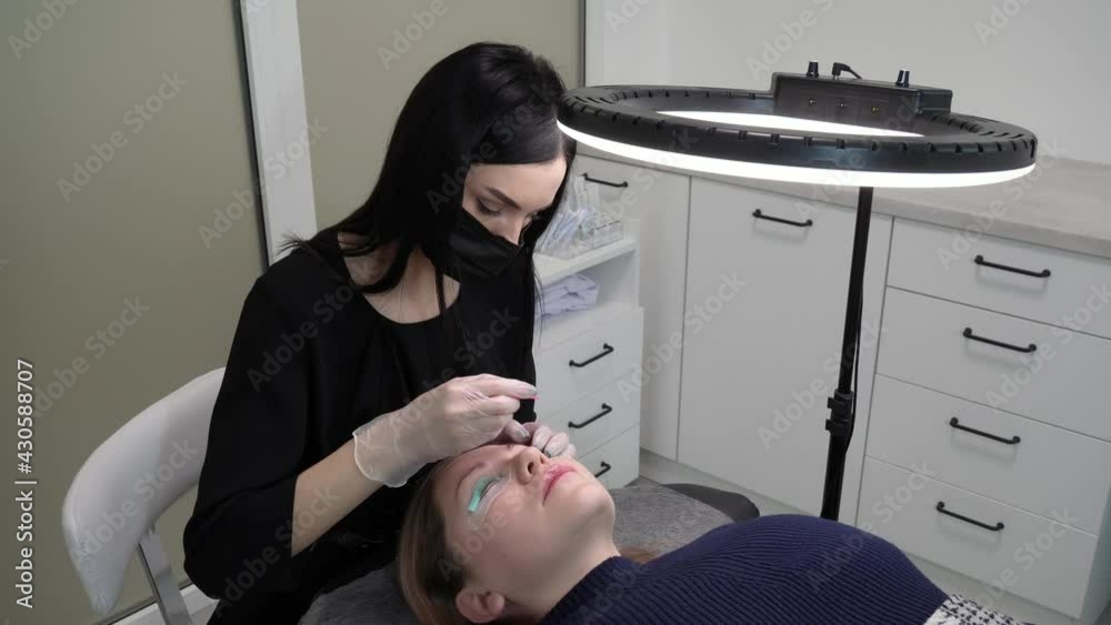Master uses a plastic comb to style the eyelashes on silicone roller ...
