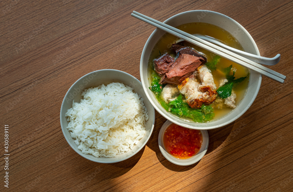 Top view Asian meal, a bowl of pig's blood soup and pork with steam ...
