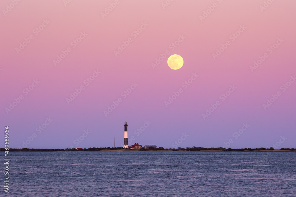 Full moon rising through the Belt of Venus behind a tall stone ...