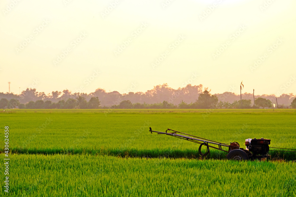 Idle walking tractor on rice field ready to be used at the beginning of ...