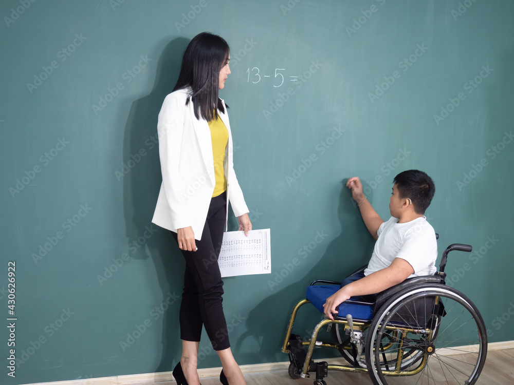 A handicapped boy in a wheelchair listening attentively to the young ...
