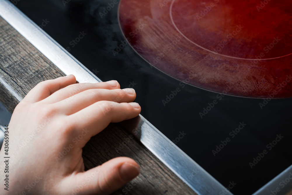 Hand Of A Child Reaches Active Hotplate Of A Kitchen Glass-Ceramic ...