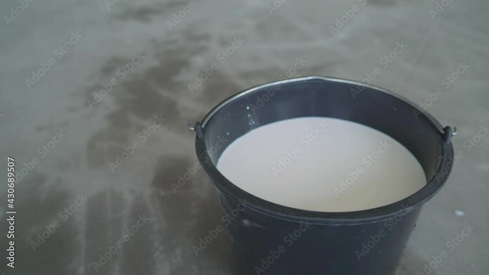 Black bucket with primer, close up. A bucket of white paint at a ...