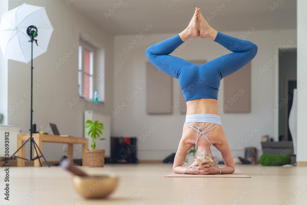 Backstage of a yoga photo shooting. The instructor performs a pose on ...