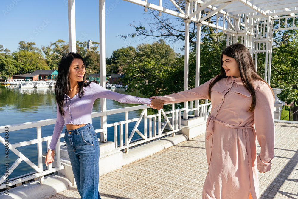 Two young friends walking holding hands playing happily on an old ...