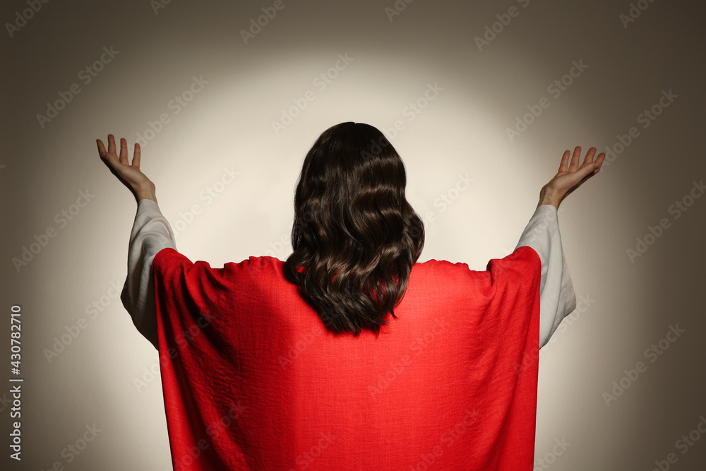 Jesus Christ with outstretched arms on beige background, back view ...