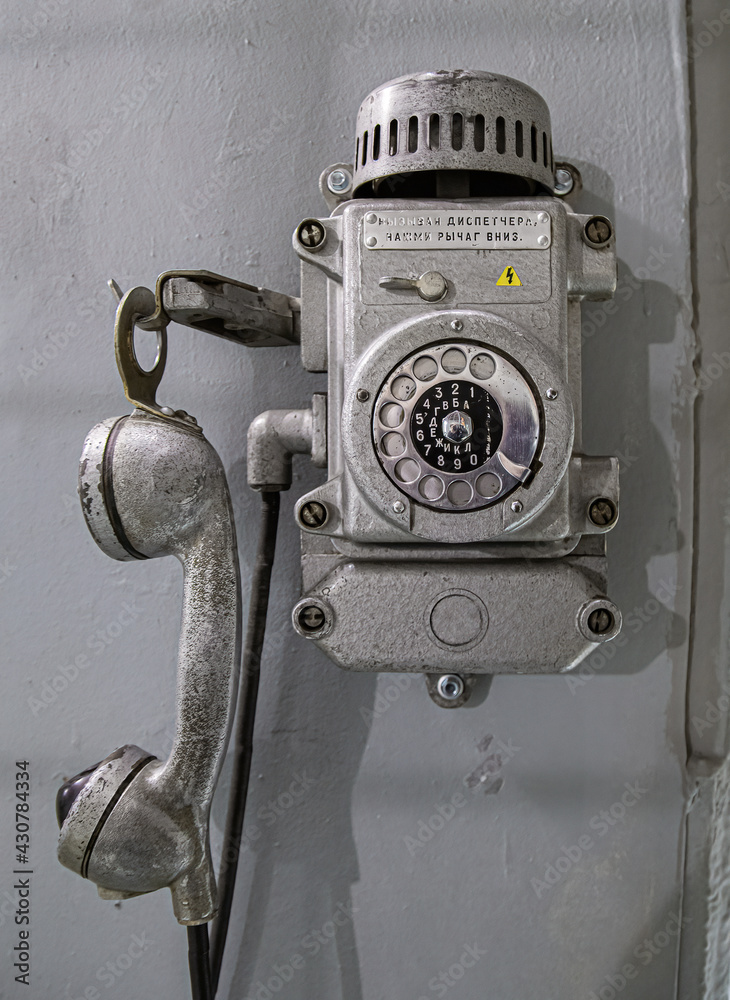 Old metal wall-mounted telephone with rotary dial. Antique phone with ...