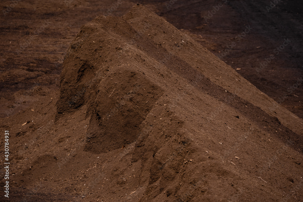 large brown peat piles can be seen in the peat extraction bog. Stock ...