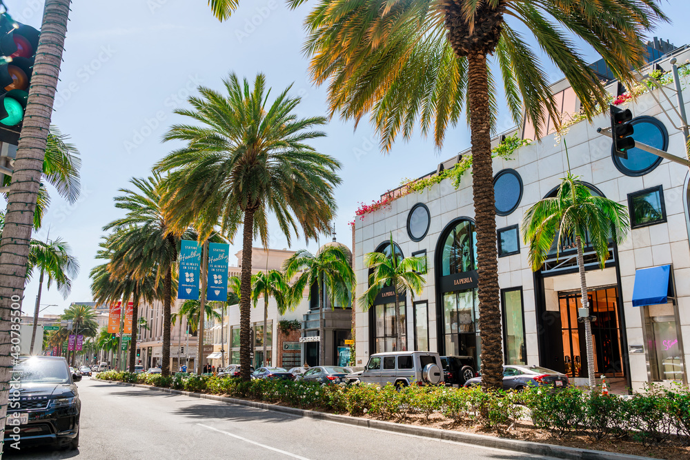 The streets of Beverly Hills, shops among palm trees, bright buildings ...