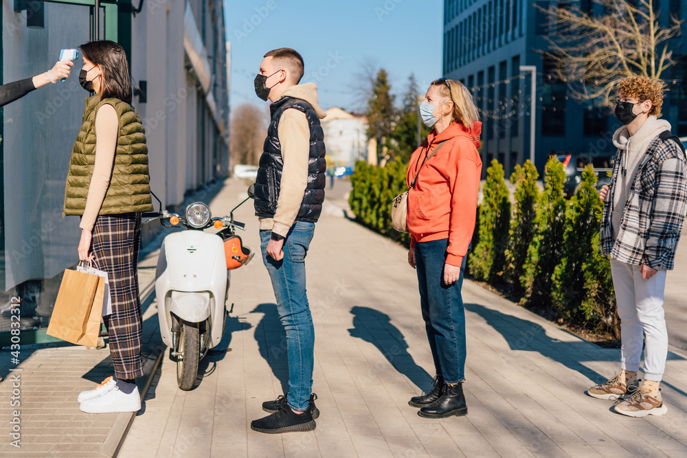 Side view of people lining up before entering at supermarket ...