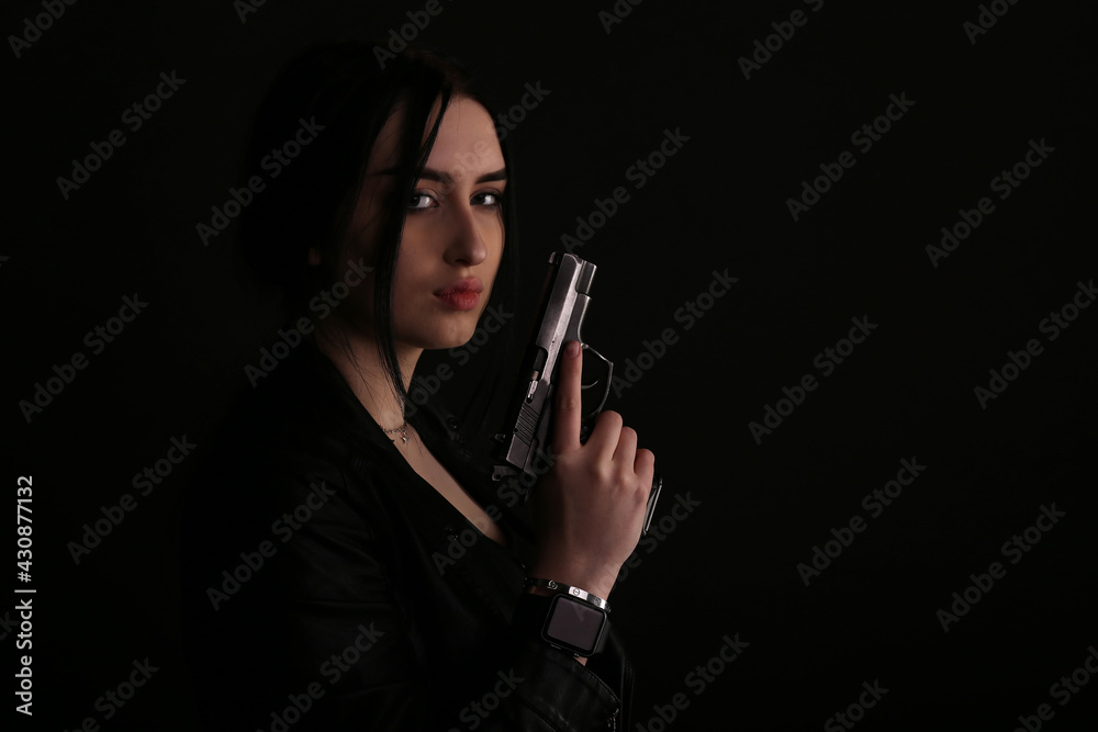 Beautiful woman with a gun in her hand Stock Photo | Adobe Stock