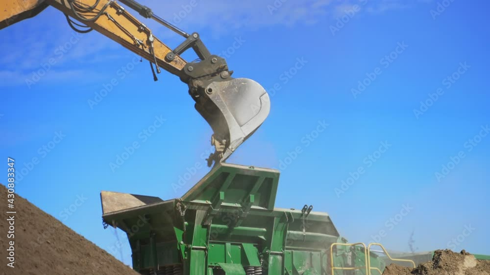 Excavator and screener machine working on construction site. Stock ...