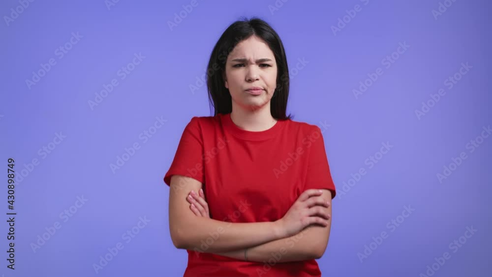 Offended woman keeping arms crossed, feeling mad at someone on violet ...