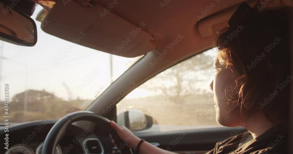 Portrait side view Attractive young woman driving car while sunset ...