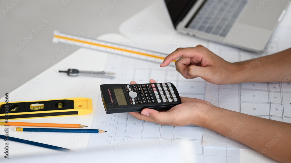 Hand using on calculator, engineers use a calculator to calculate house ...