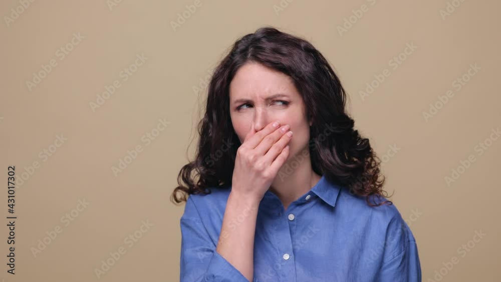 Bad smell reaction. Brunette woman grabbing nose with hands to avoid ...