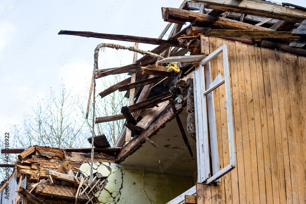 Demolition of an old two-story wooden house. Half destroyed building ...
