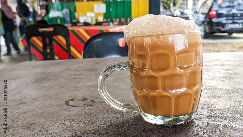 An image of teh tarik or also known as tea with milk served in a glass ...