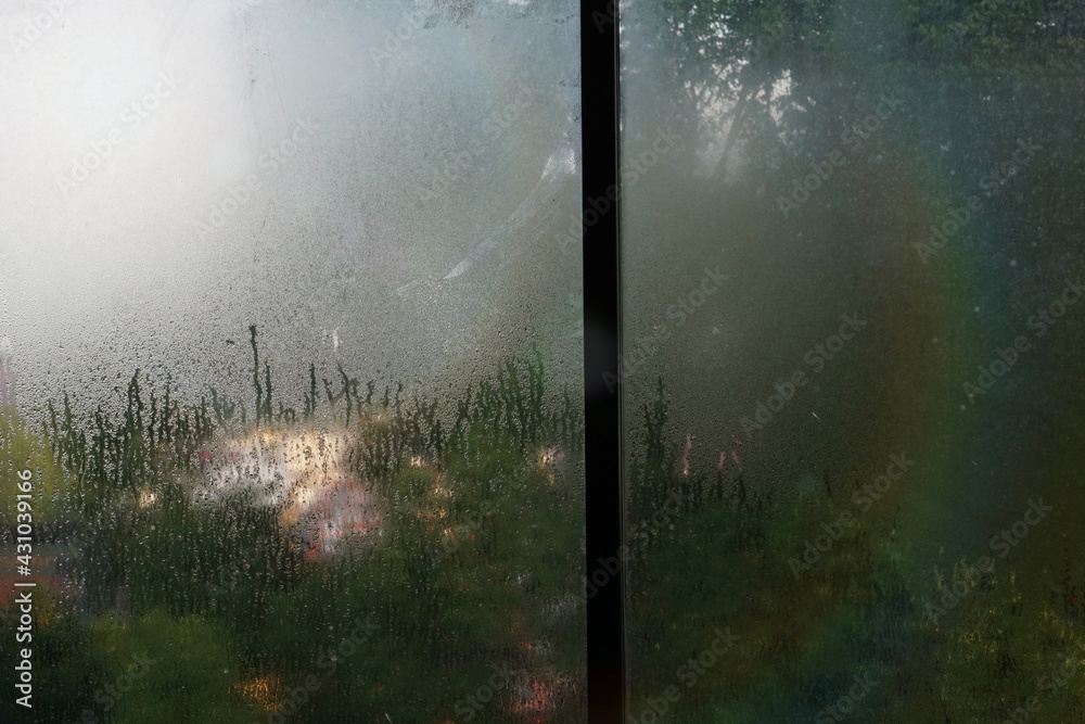 Water droplets adhere to the glass as the air inside the room is colder ...