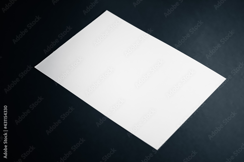 Blank A4 paper, white on black background as office stationery flatlay ...