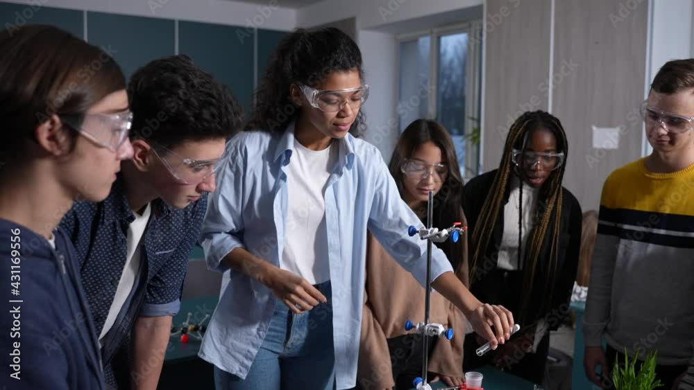 Curious multiethnic pupils in goggles observing mixed race woman ...