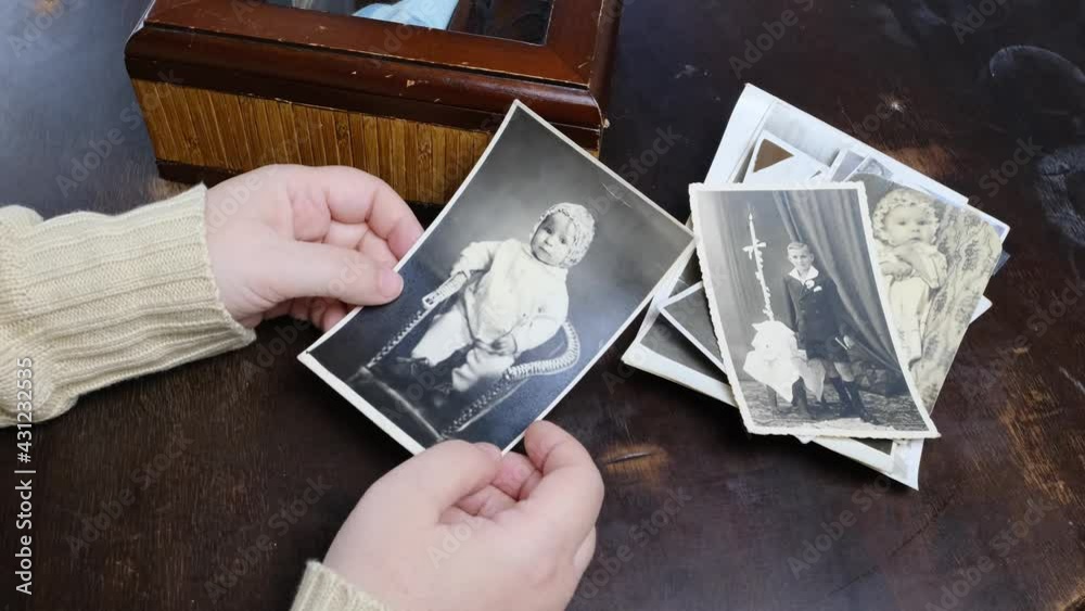 female hands fingering memorabilia in an old wooden box, a stack of ...
