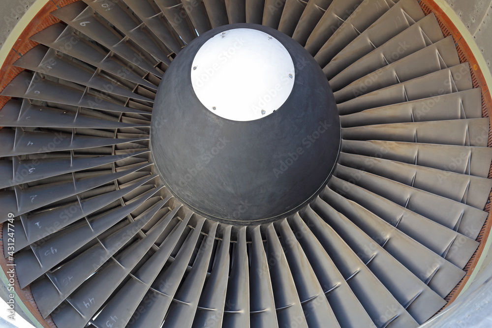 The metal fins, AKA strakes, of a jet engine are shown in a closeup ...