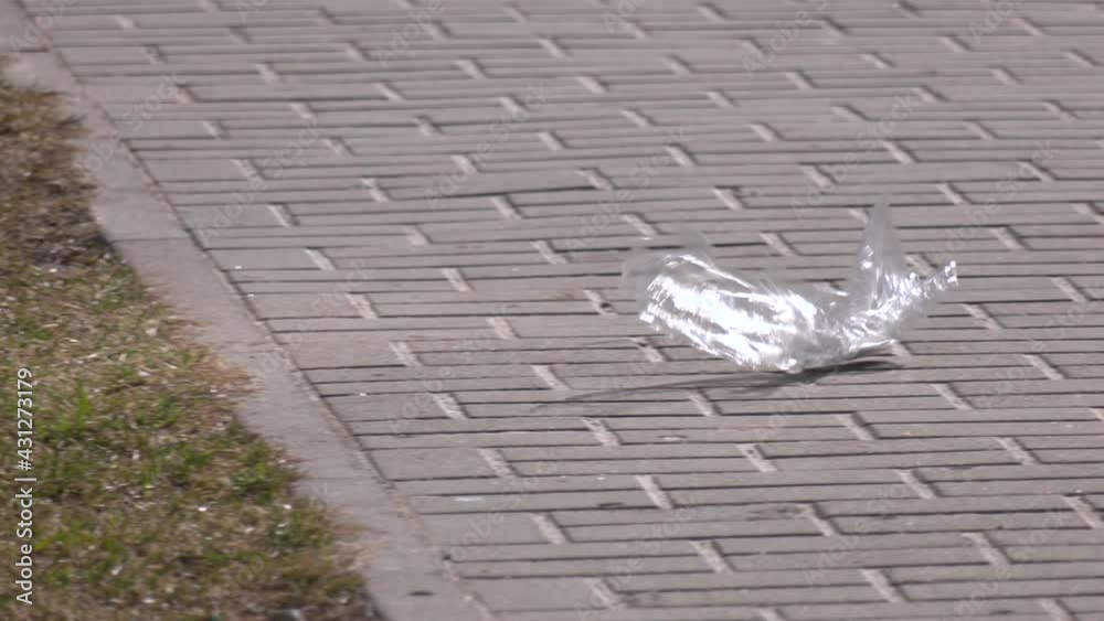 A plastic bag blows on the sidewalk. Plastic bag thrown on the street ...