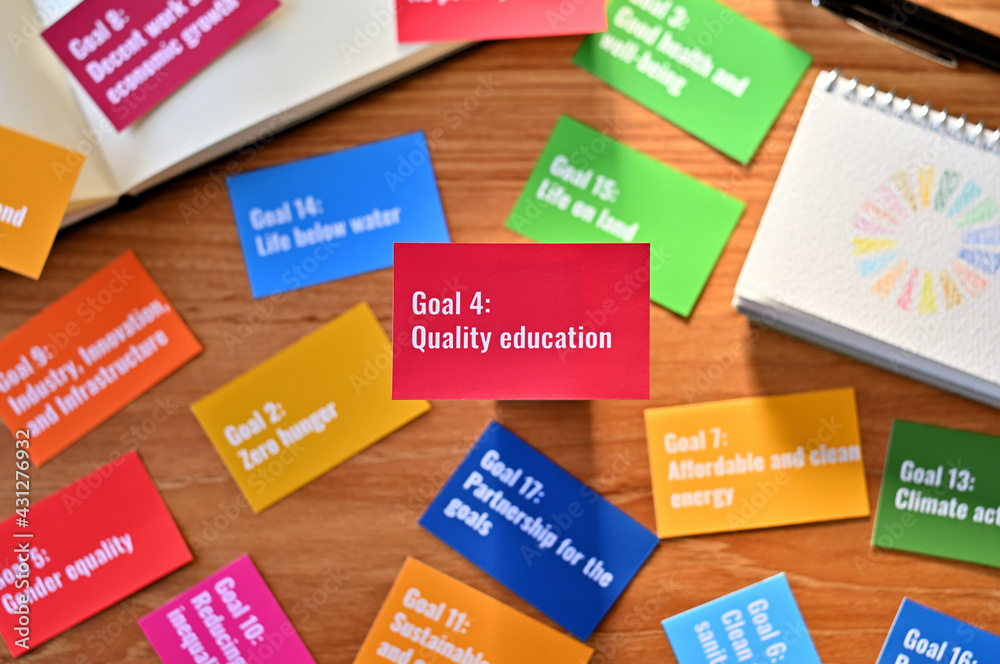There is a card with the statement Goal 4:Quality education on table ...