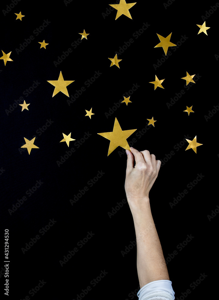 Woman's arm catching bright stars in the night sky. Black background ...