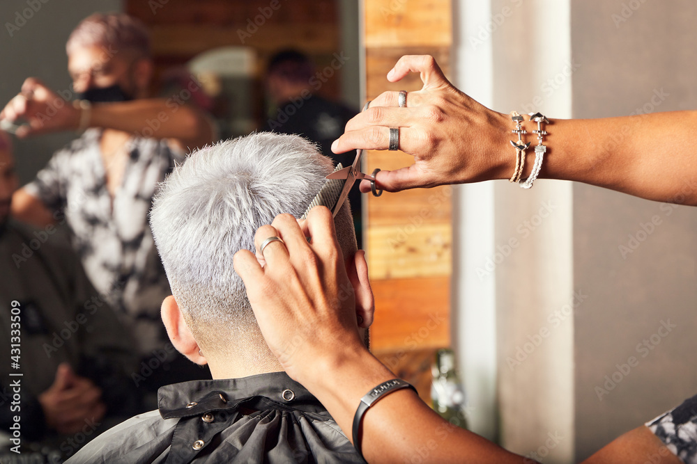 Foto de Close up of latin barber hands cutting hair with scissors. Back ...