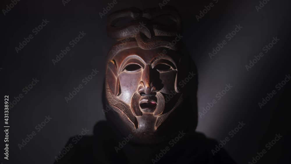 Creepy, masked cultist standing in a dark room. Scary horror scene ...