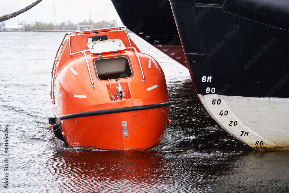 Totally Enclosed Lifeboat floating near big vessel Stock Photo | Adobe ...